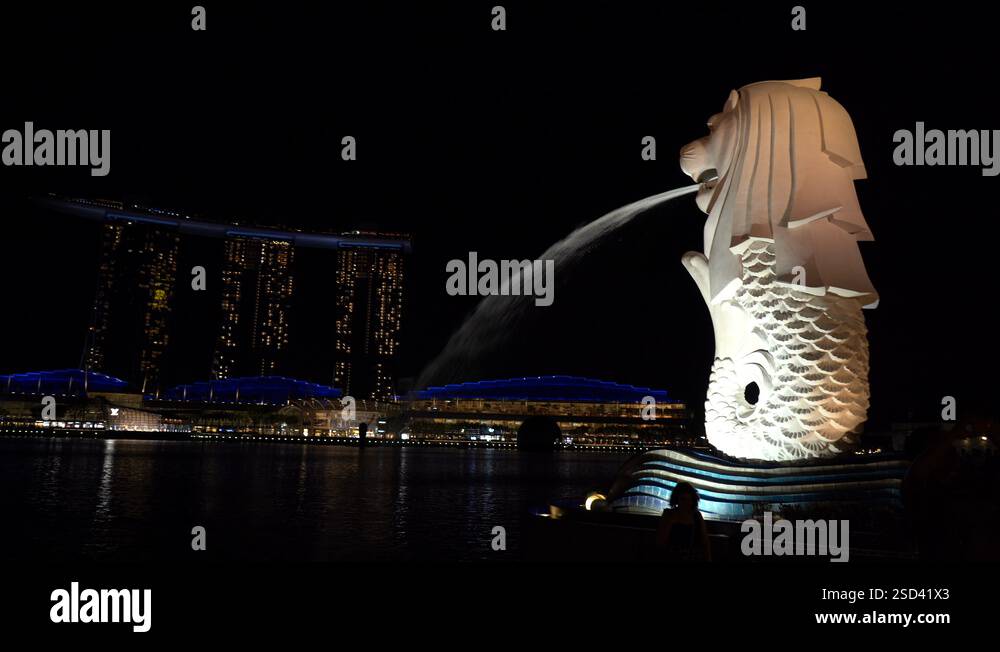 Panning shot of the famed landmark the merlion spouting water with ...
