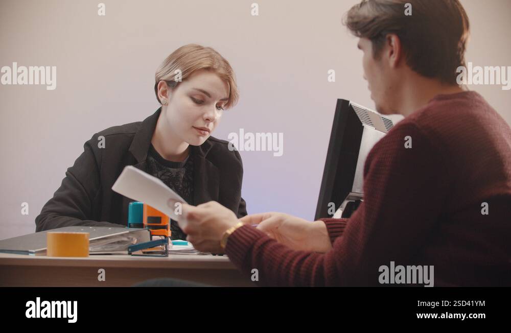 office - a woman is telling what is on the documents and man is ...
