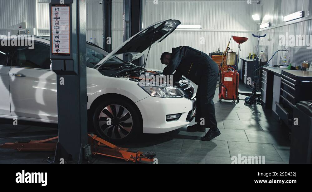 Attractive mechanic with a good mood in a uniform dancing funny in ...