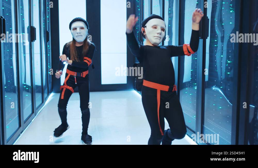 Masked anonymous kids in black spy costumes dancing in middle of server ...