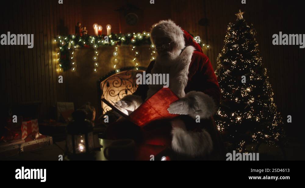 Authentic santa clause opening his magical shining book with red cover ...