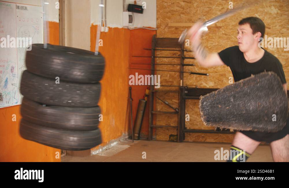 A man knight training in the gym with the sword - training on the bunch ...