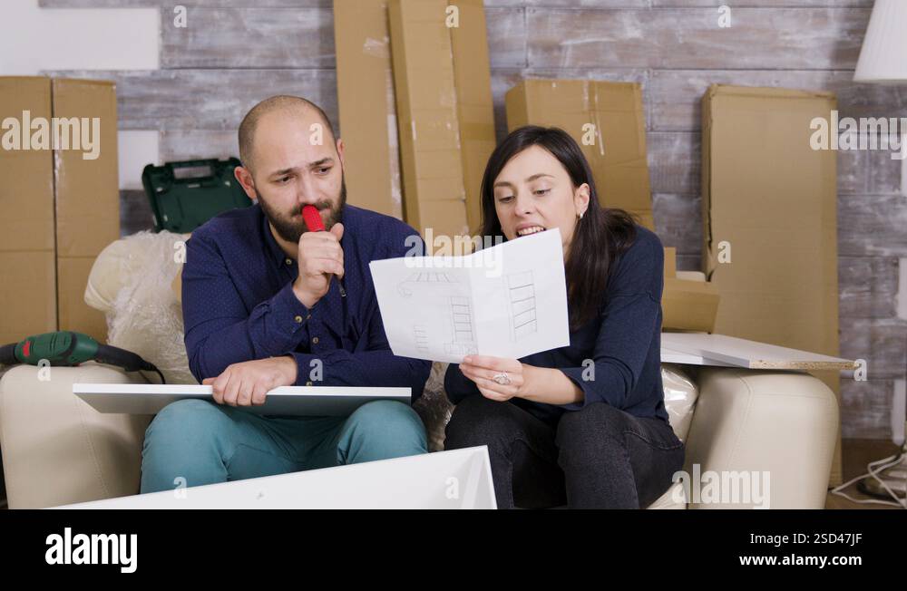 Angry girlfriend hitting boyfriend with furniture instructions Stock ...