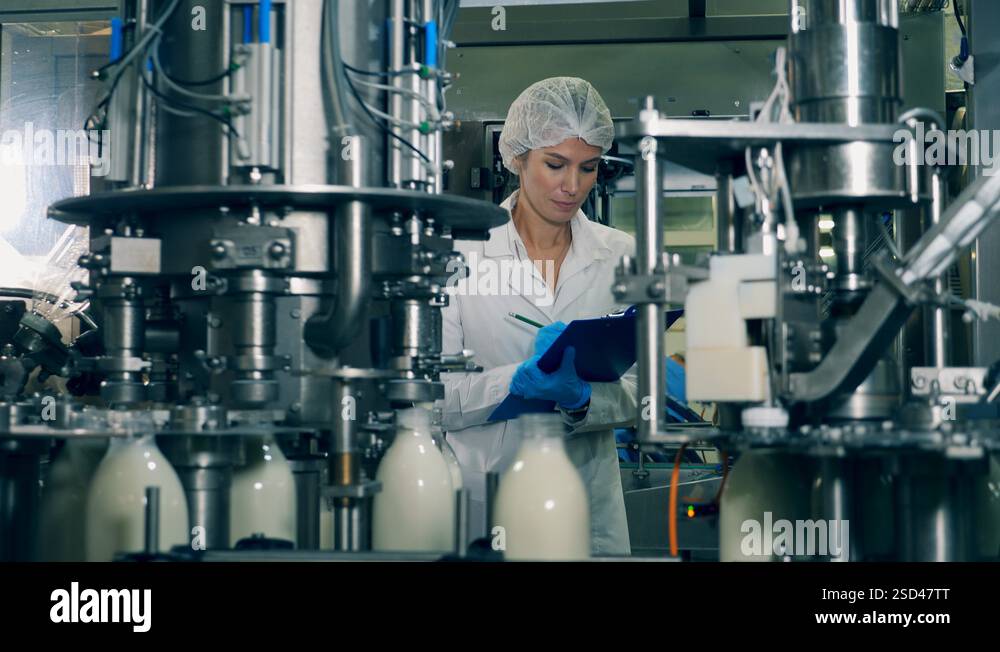 Dairy factory unit at work with a female employee observing it Stock ...