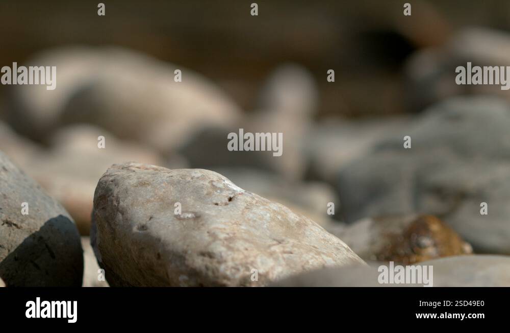 MACRO, DOF: Pebble shatters into pieces after falling onto the rocky ...
