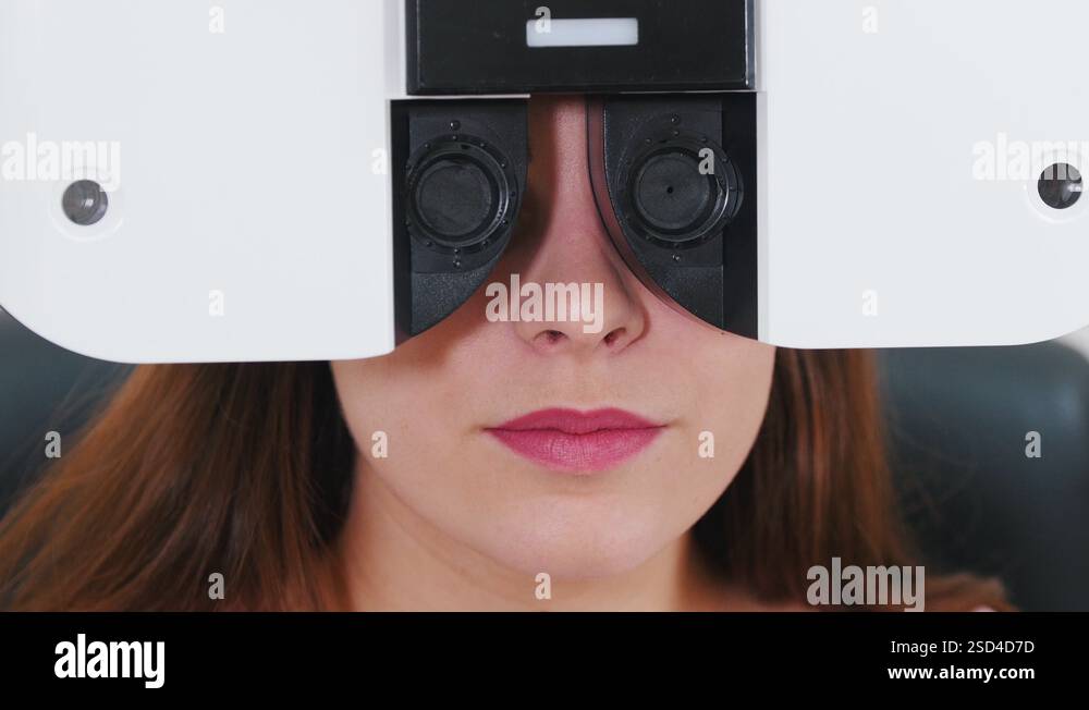 Ophthalmology treatment - a young woman checking her visual acuity with ...