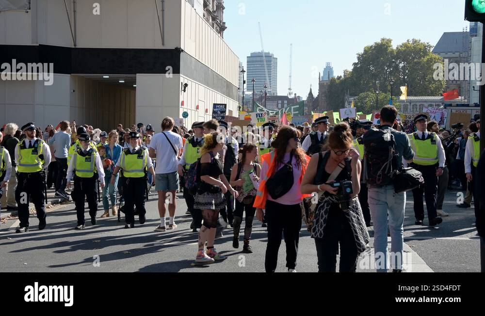 A line of police officers walking slowly ahead of an Extinction ...