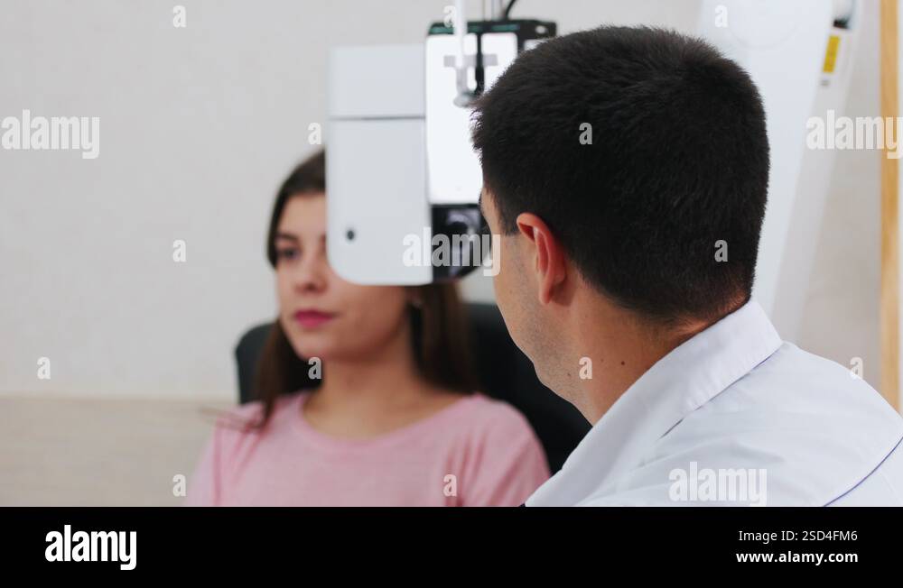 Ophthalmology treatment - a young woman checking her visual acuity with ...
