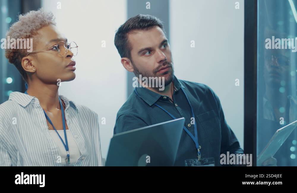 Multi-ethnic IT cyber engineers opening and analyzing rack server cabinet Stock Video Footage ...