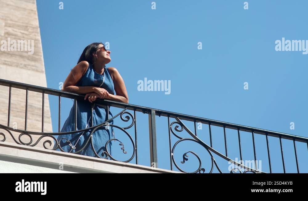 Relaxed elegance tanned female in dress enjoying sunshine standing on ...