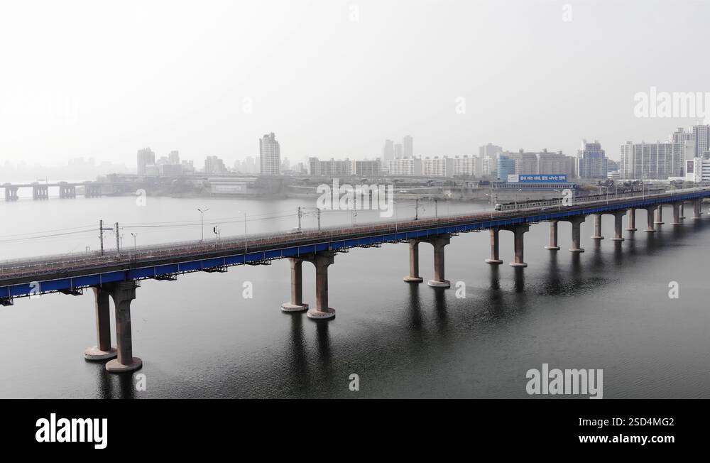 Metro train crossing river, move by railway bridge, cinematic aerial ...