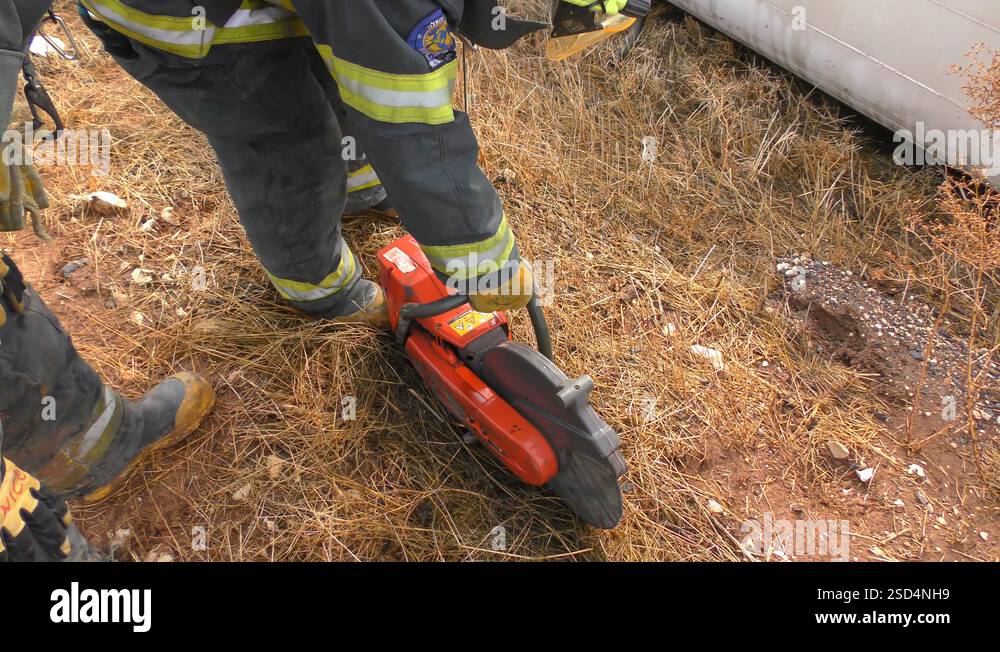 Firefighter starting a huge rotary saw for opening a hole in a derailed ...