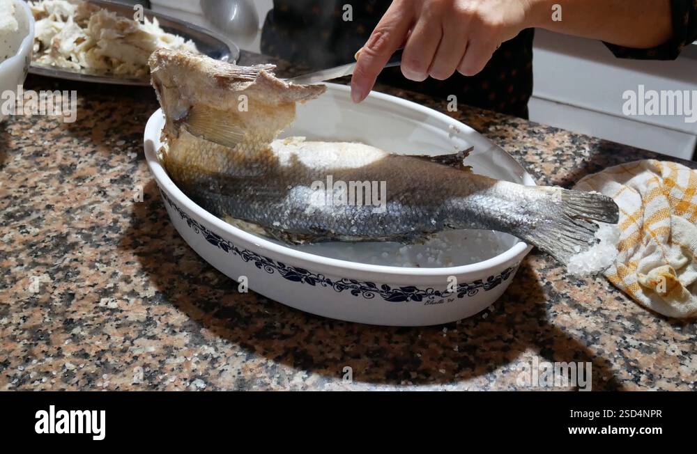 The cook cleans the baked fish in salt Stock Video Footage - Alamy