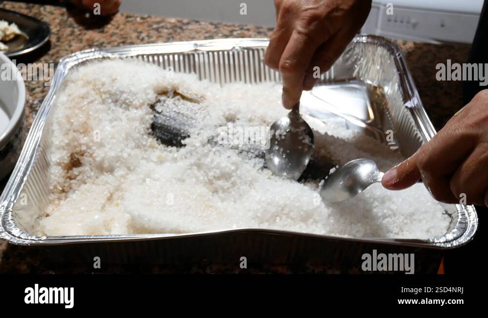 The cook cleans the baked fish in salt Stock Video Footage - Alamy