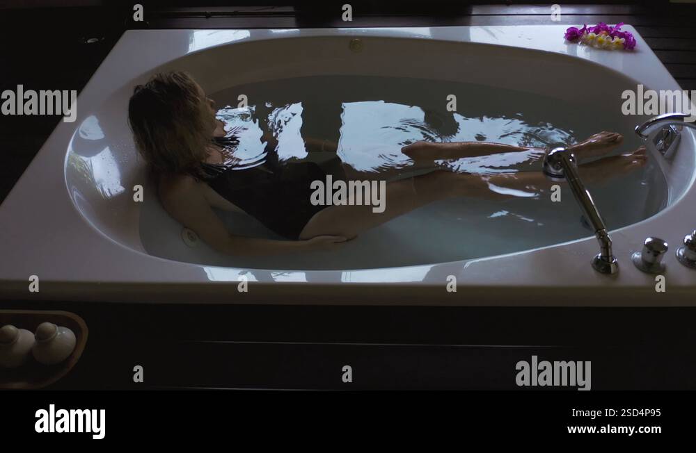 Tender-hearted pretty young girl chilling out in the bathroom while ...