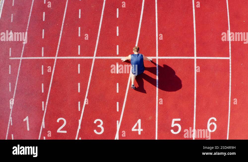 Top view of a track runner athlete at starting line on stadium lane, 4k ...