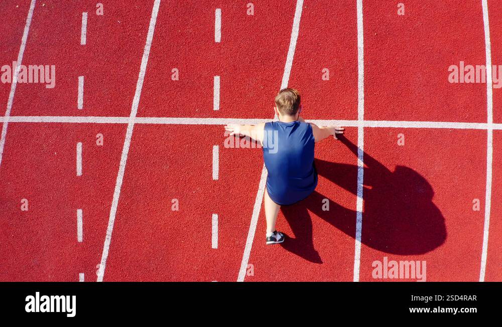 Top view of a track runner athlete at starting line on stadium lane, 4k ...