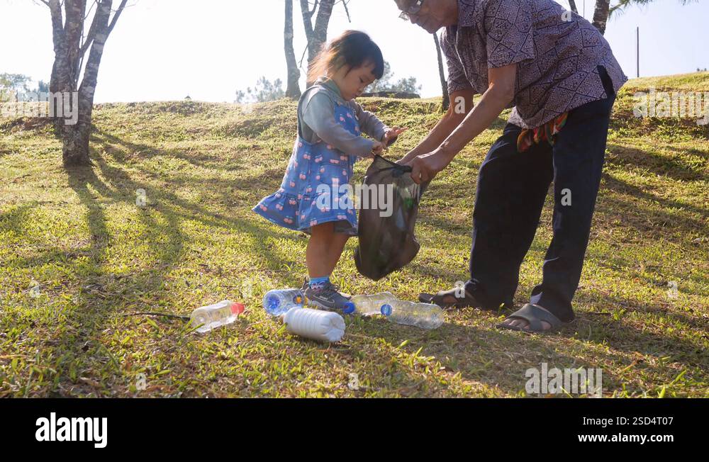 Asian family help to clean garden by collect plastic water bottles for ...