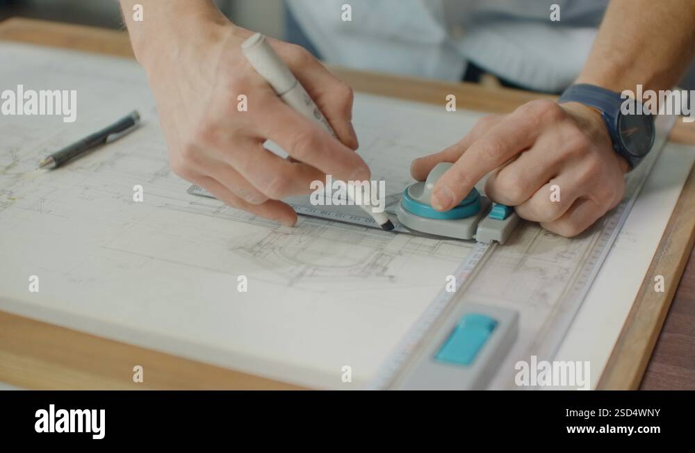 A male architect creates a drawing of a building on paper. To study the ...