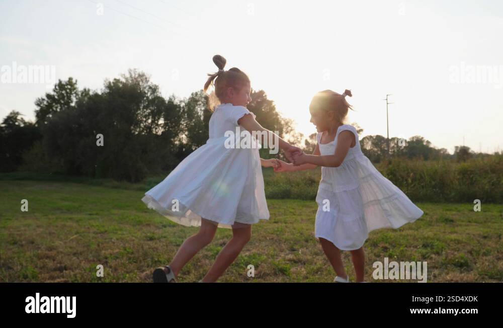 Two little sisters are embracing and enjoying their time together in a ...