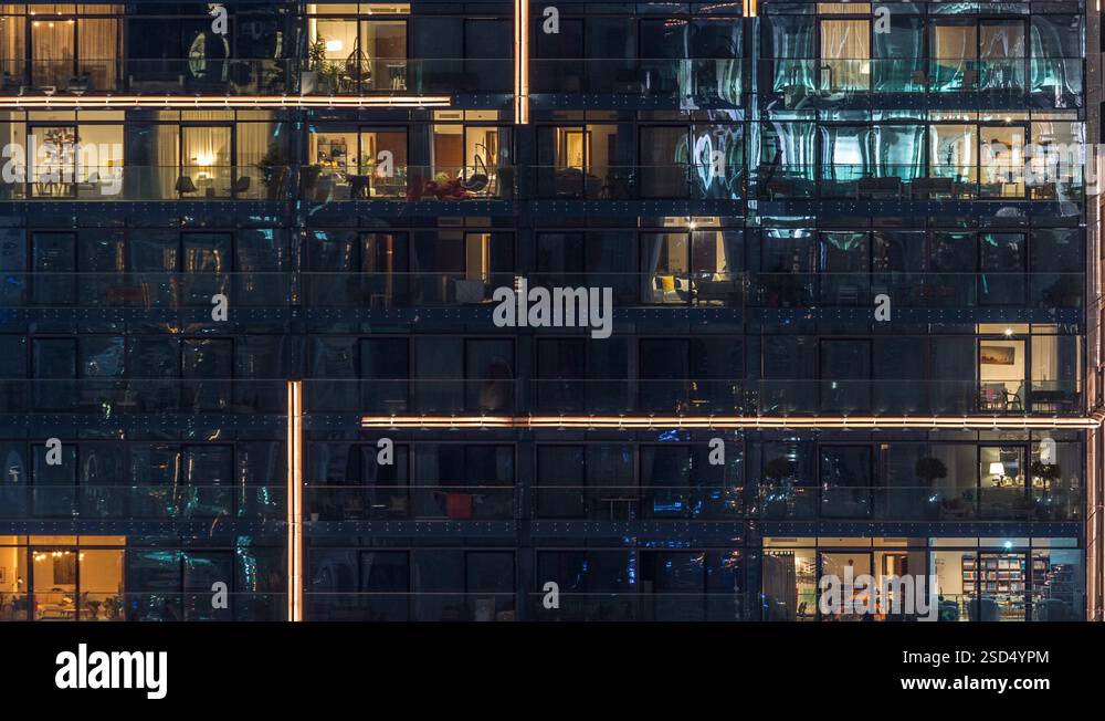Lights in windows of modern multiple story building in urban setting at ...