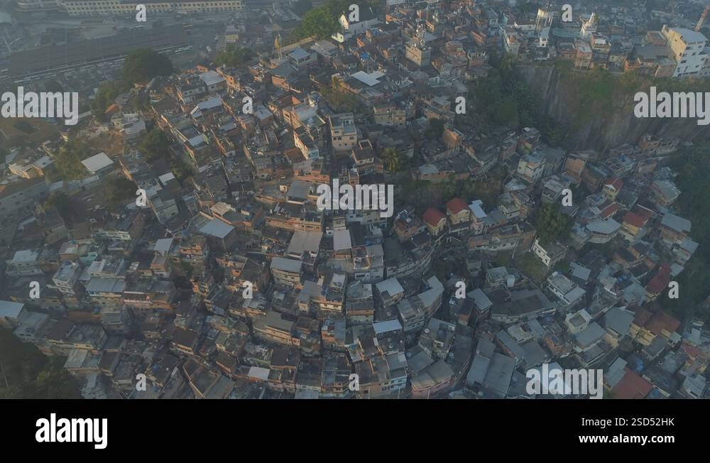 Aerial tilting down over favela houses on hilltop in Rio de Janeiro ...