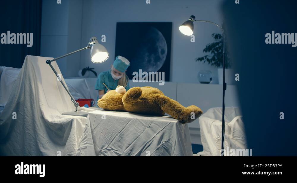 Girl playing doctor surgeon at home making notes about her teddy bear ...