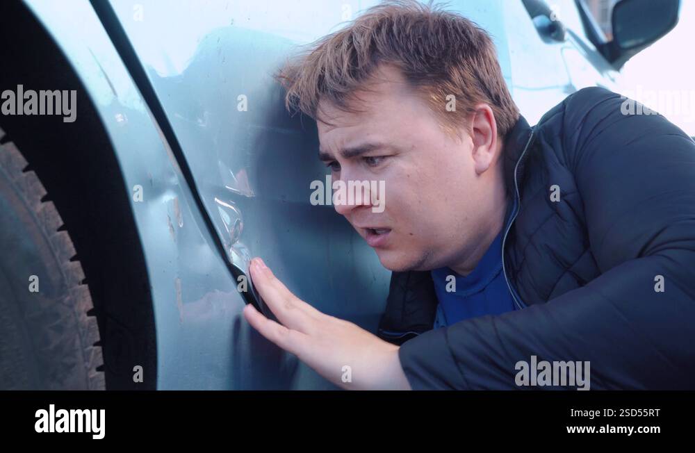 Broken automobile in parking lot. Guy is crying hysterically because ...
