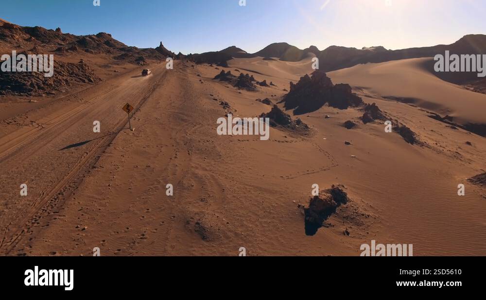 Lone car drives the desert road crossing the Moon Valley. The landmark ...