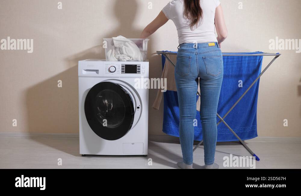 lady takes laundry of washing machine and hangs out on rack Stock Video ...