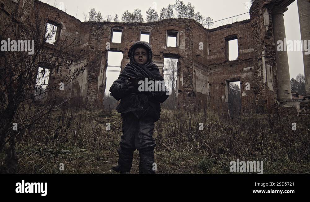 Homeless boy carries water in a bowl on the ruins. War. Apocalypse ...