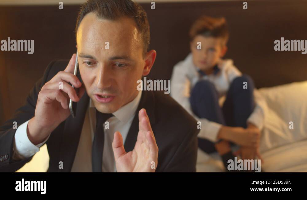 Man talk on phones emotionally in hotel room, boy sit on the bed and ...