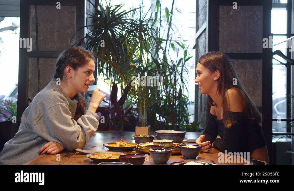 Two girls sit in a cafe and talk friendly Stock Video Footage - Alamy