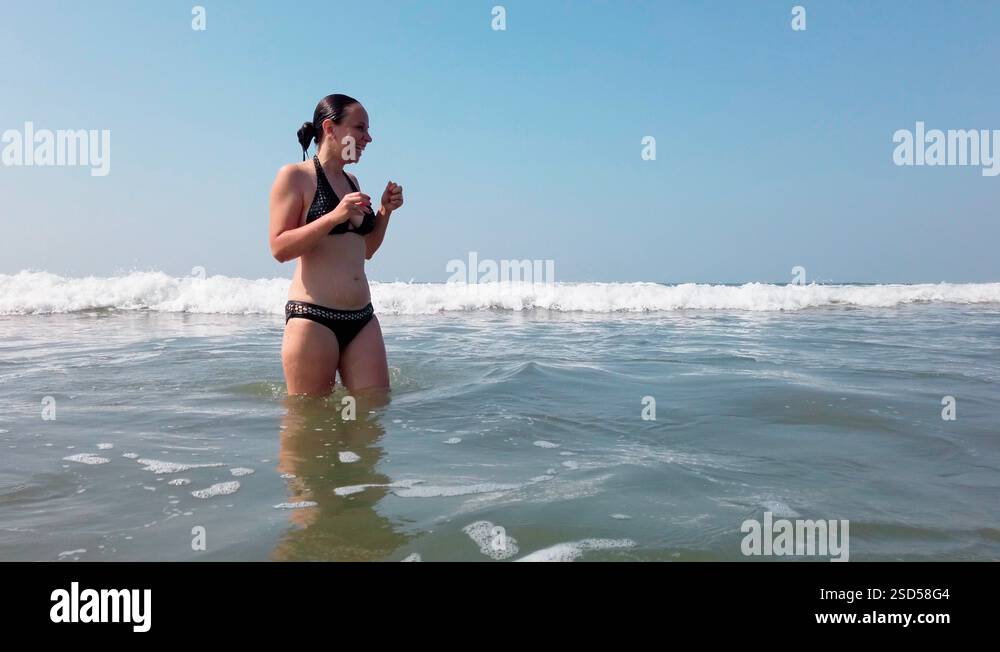 Woman waiting for sea wave. Side view of wet female swimming in sea water and Stock Video ...