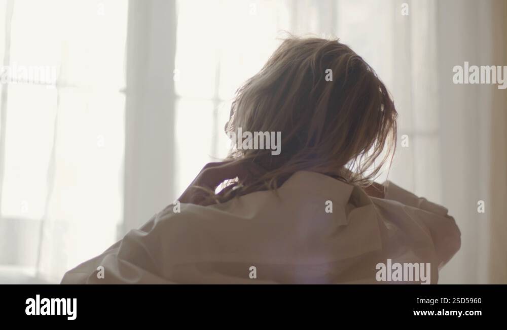 Close-up back view of sensual Caucasian girl touching hair in sunrays ...