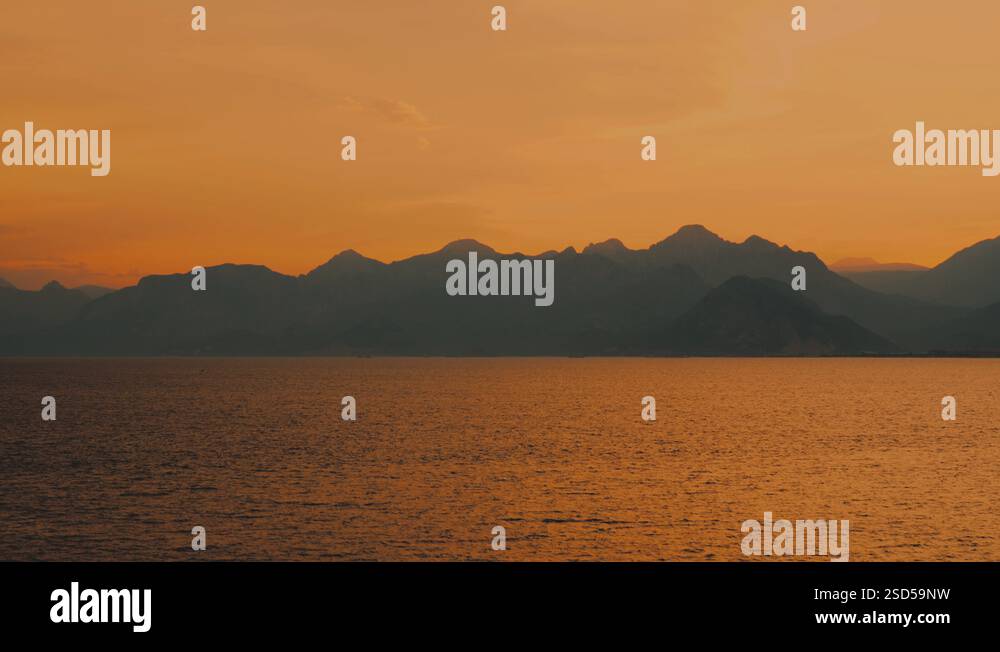 panoramic landscape of sunset golden sky, dark sea water and orange ...