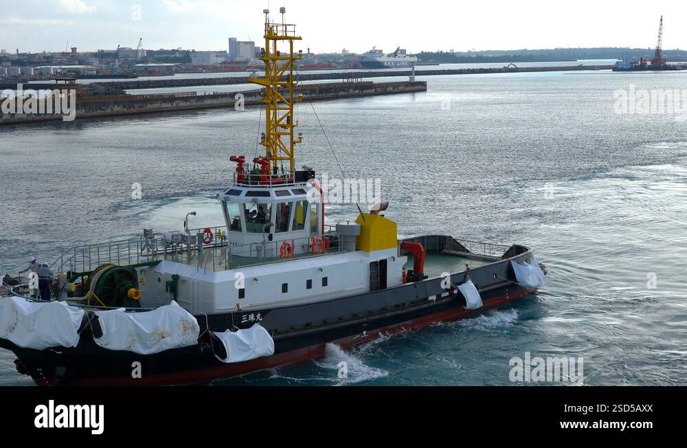 Tugboat workers working in a port pile ropes. Bright industrial tugboat ...