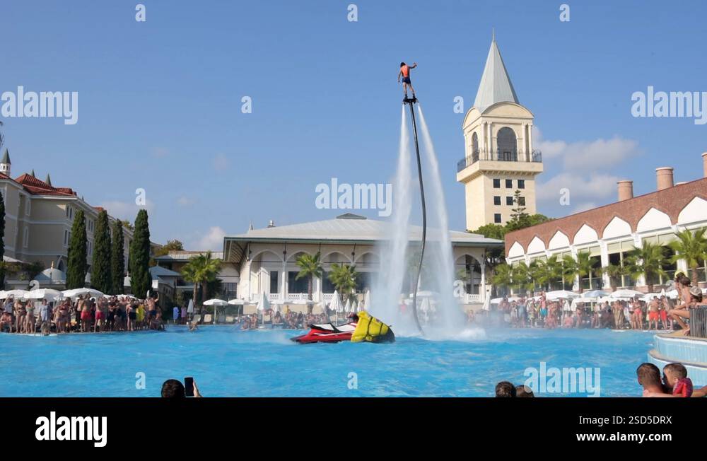 Man in wetsuit on flyboard fly in pool hotel on air jet or water ...