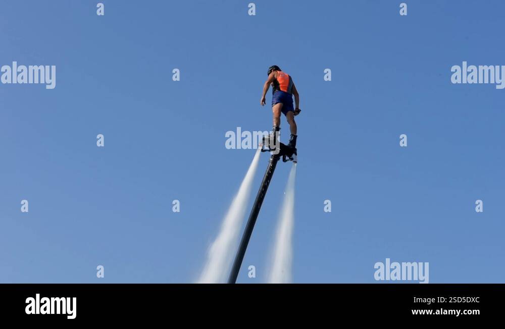 Man in wetsuit on flyboard fly in pool hotel on air jet or water ...