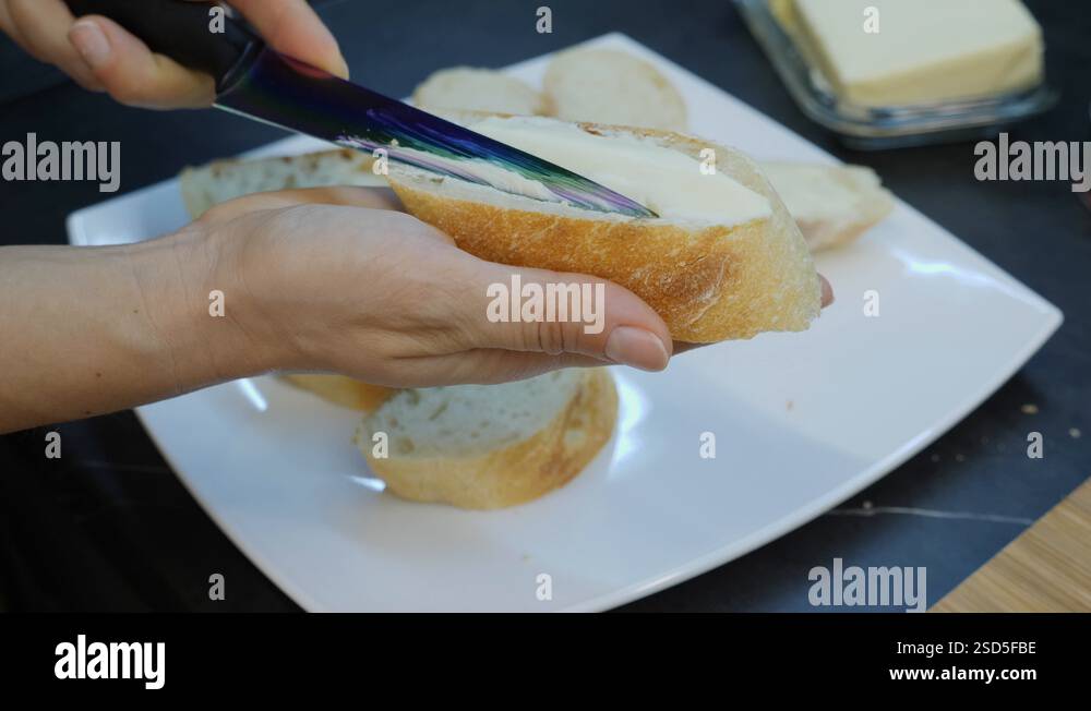 Hands spreading white butter on white bread. Chef smears white ...
