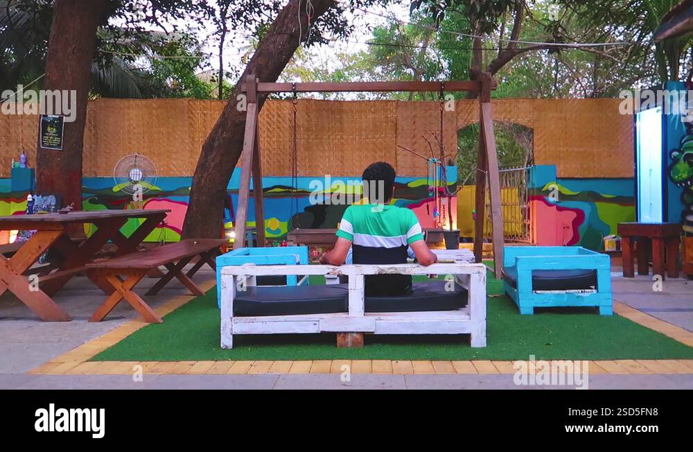 A young man sitting and relaxing in a famous beach resort in Goa Stock ...