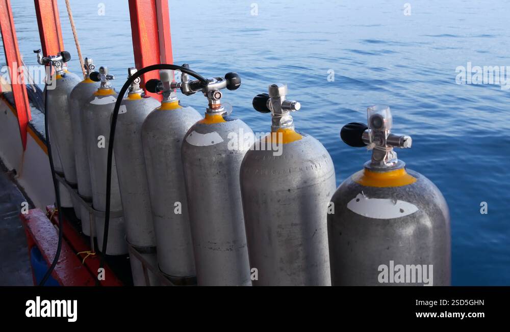Row of oxygen tanks and diving equipment placed on modern boat in ...
