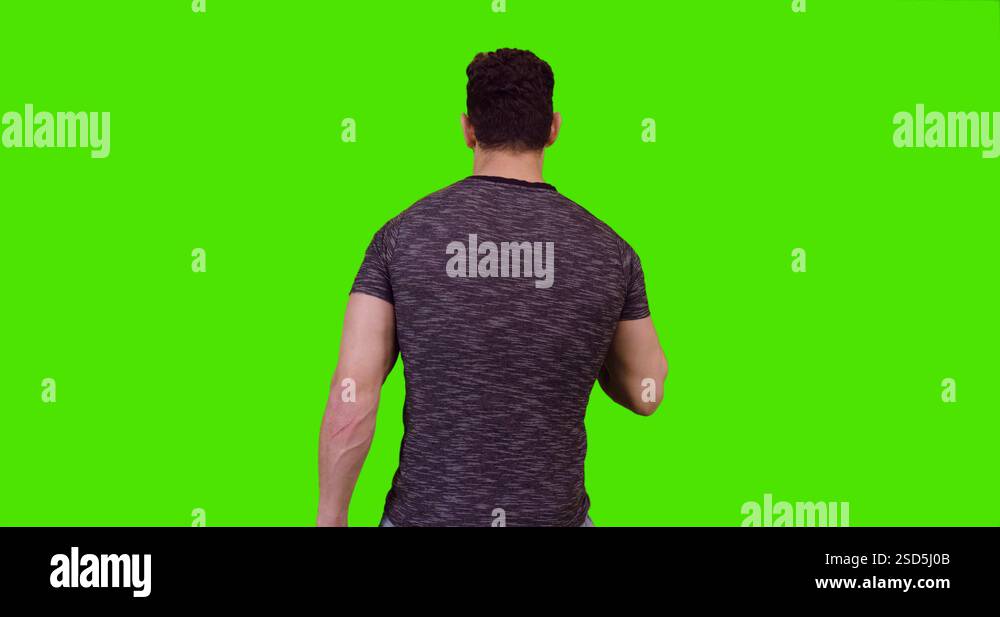 Young man drops his barbell while looking to the side, over green ...