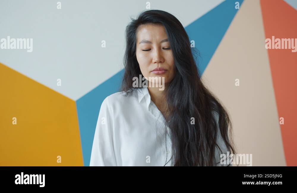 Slow motion of sad Asian girl looking at camera with serious unhappy ...