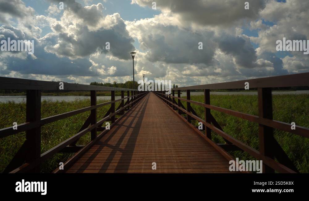Empty wooden footbridge walking. Bridge connecting two shores of lake ...
