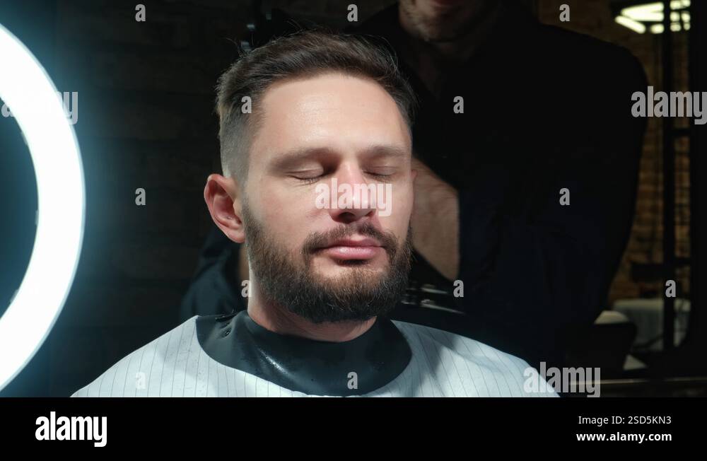 Hairdresser combing a beard to a man. Beard style process. Working ...