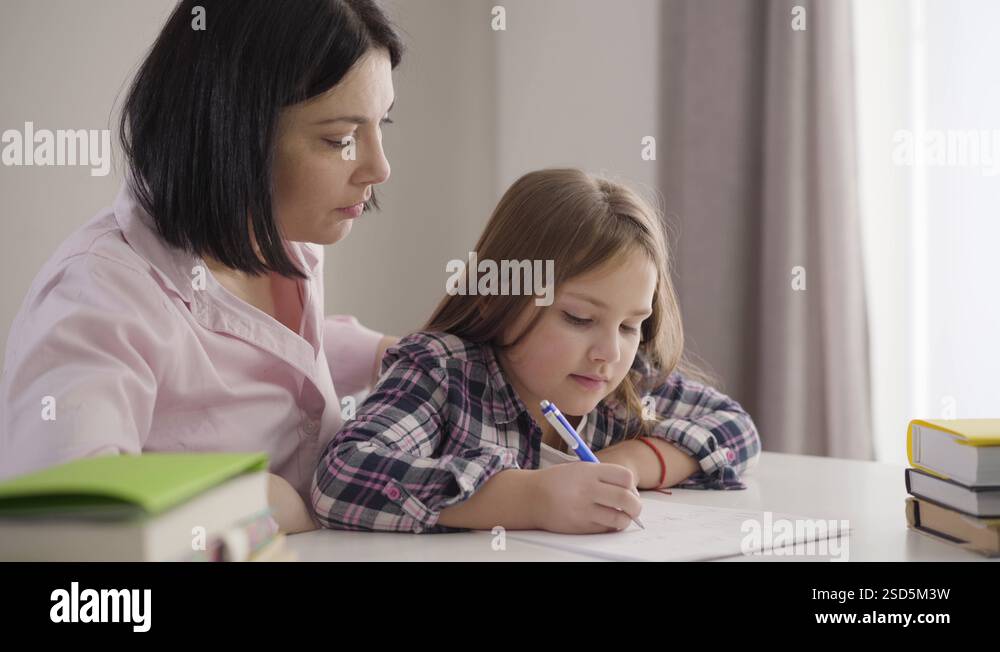 Close-up portrait of pretty Caucasian schoolgirl doing homework with ...