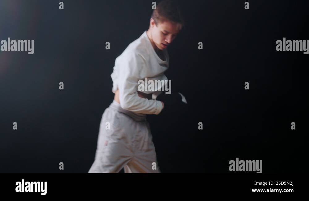 Young fit man break dancer in white clothes spinning aroung on one hand ...