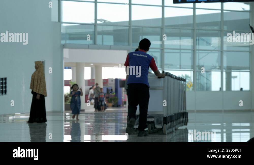 Airport helper pushes empty airport trolley, rear view Stock Video ...