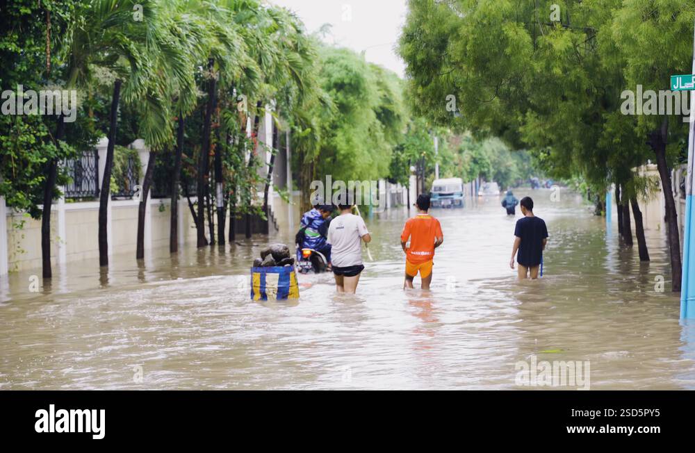 People walk across the flooding street in Jakarta Stock Video Footage ...